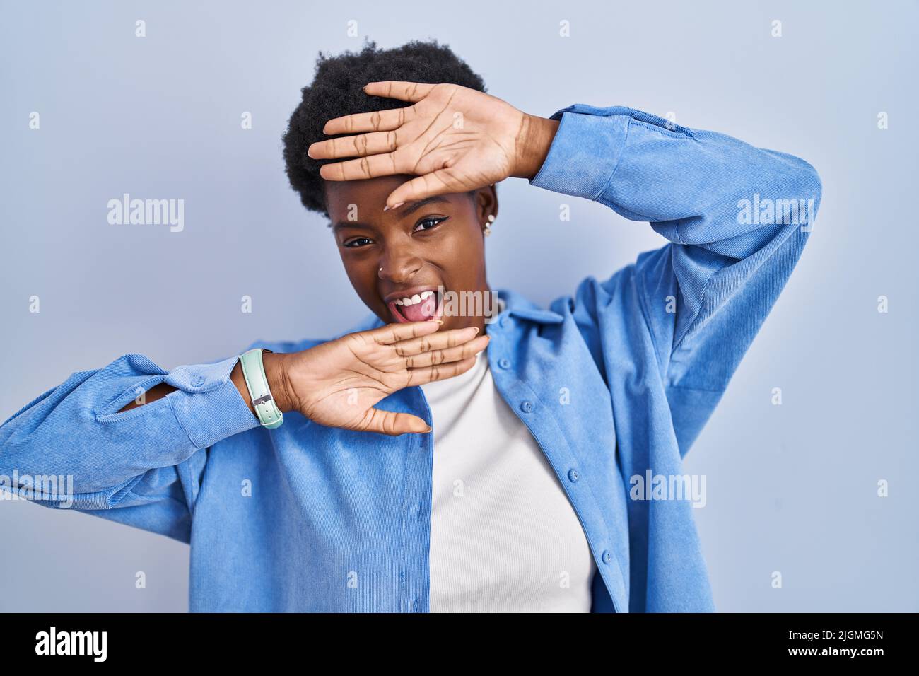 African american woman standing over blue background smiling cheerful ...