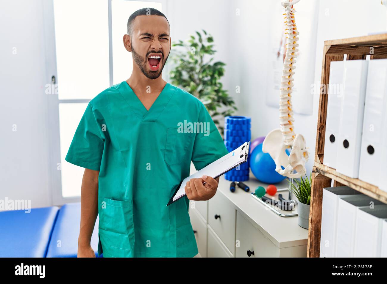African american physiotherapist man working at pain recovery clinic ...
