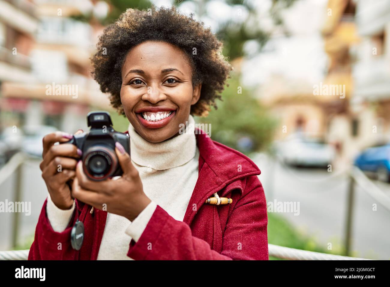 Young african american woman holding dslr camera at the city Stock ...