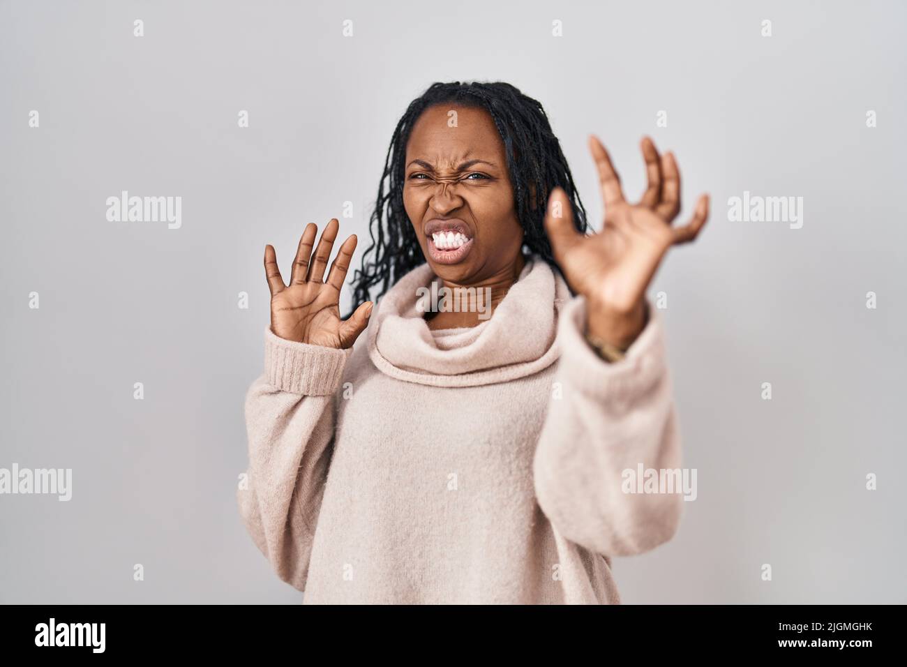 African woman standing over white background afraid and terrified with ...