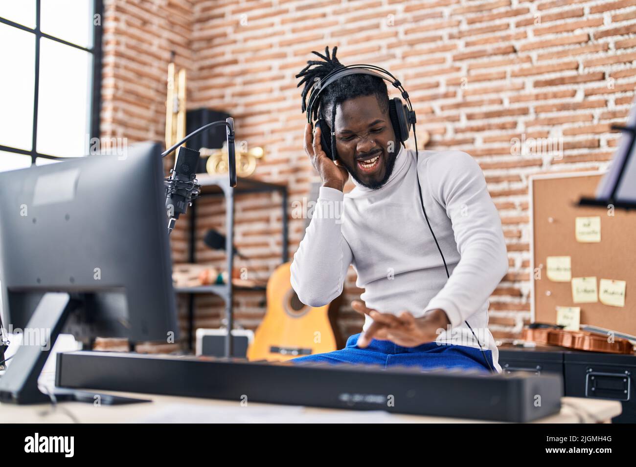 African american woman musician playing piano keyboard at music studio ...