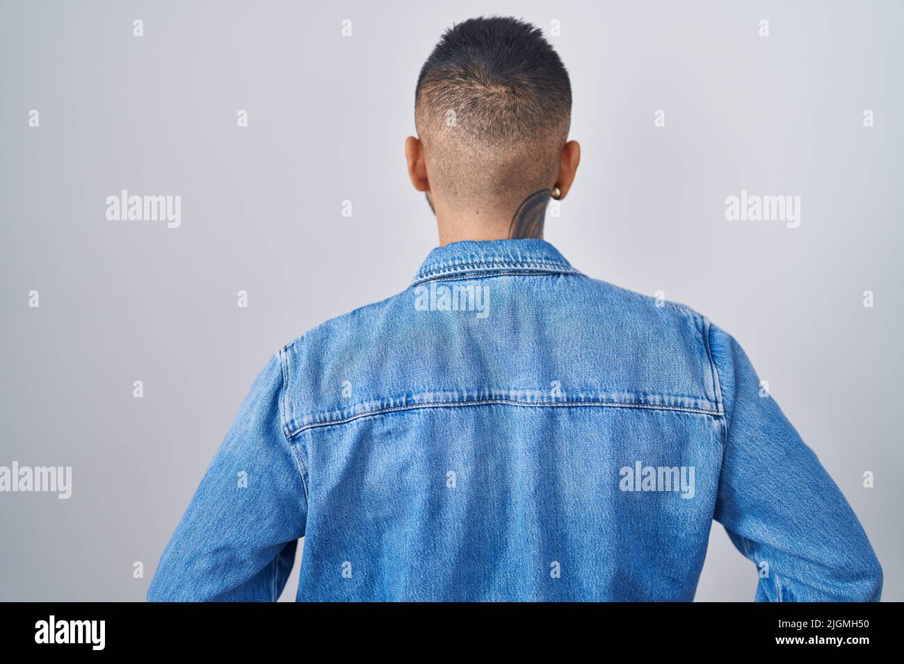 Young hispanic man standing over isolated background standing backwards ...