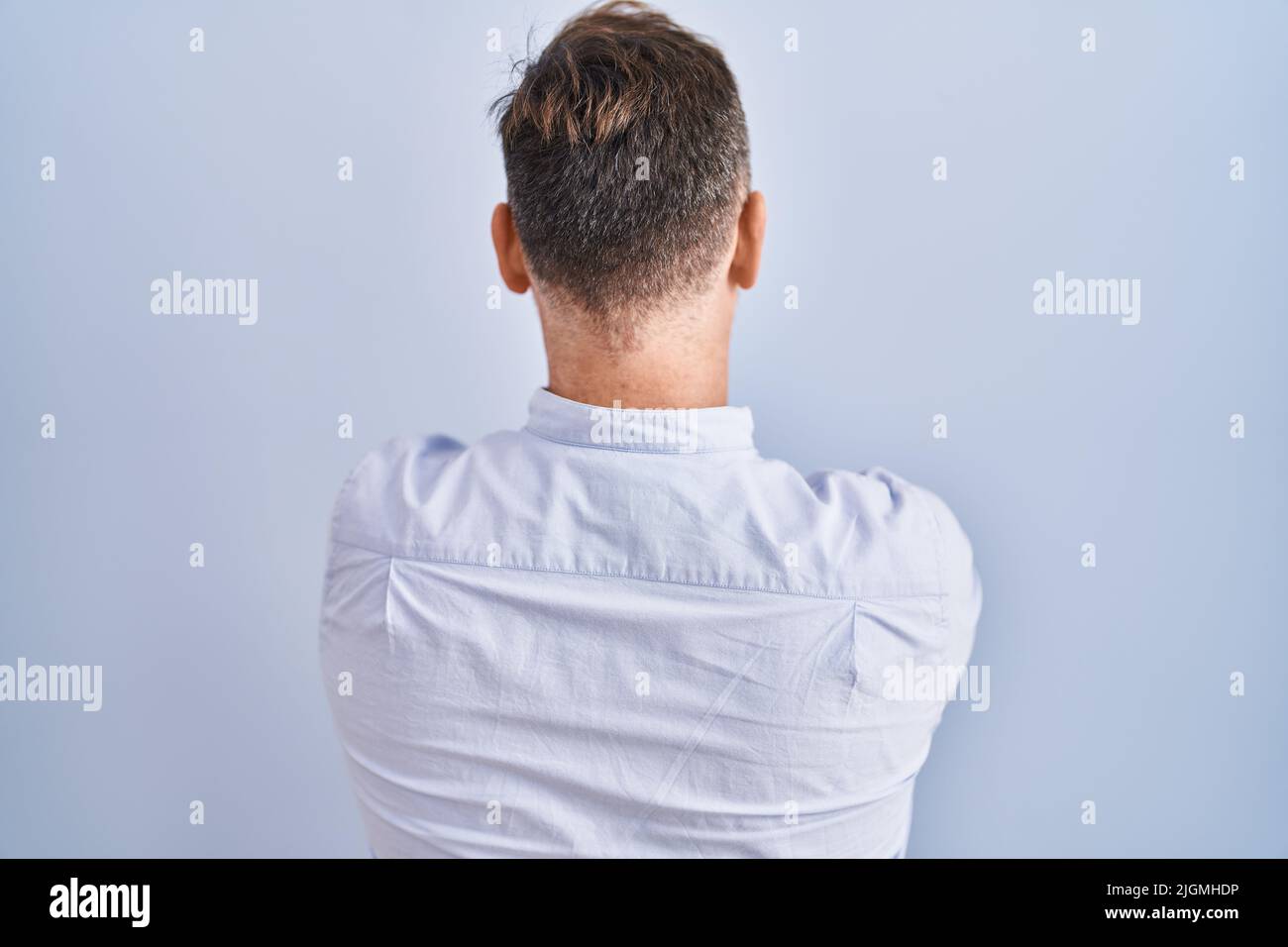 Middle age caucasian man standing over blue background standing ...