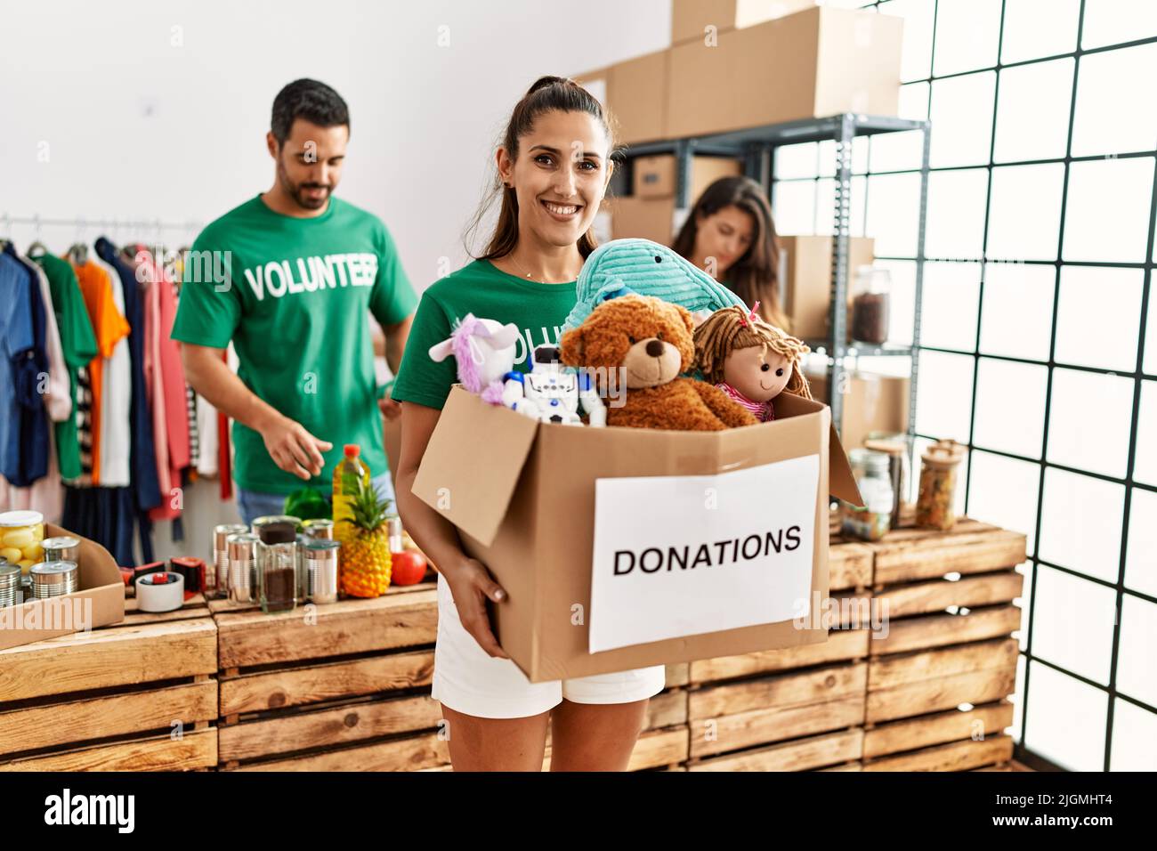 Group of hispanic volunteers working at charity center. Woman smiling ...