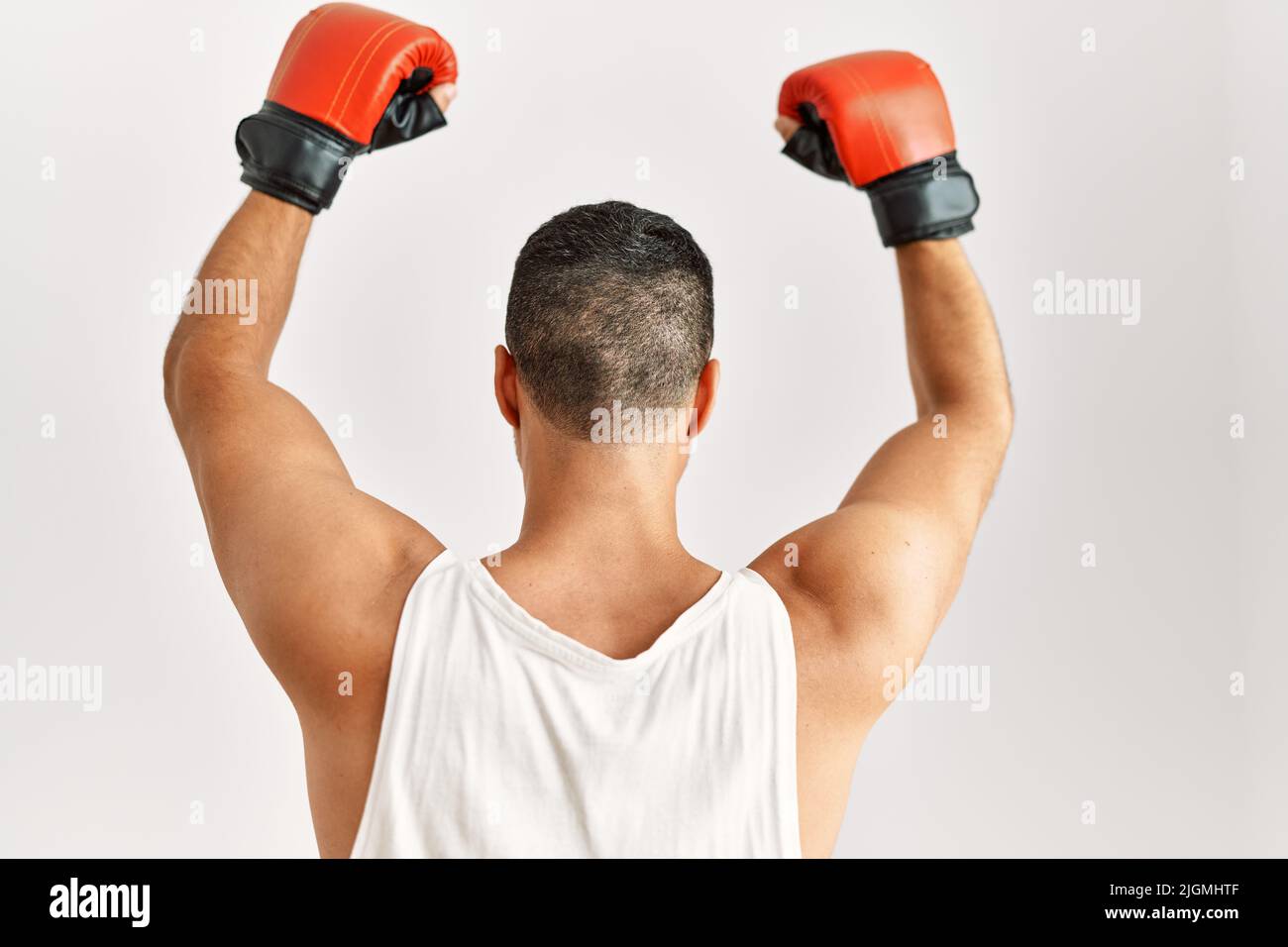 Young hispanic man on back view doing strong gesture over isolated ...