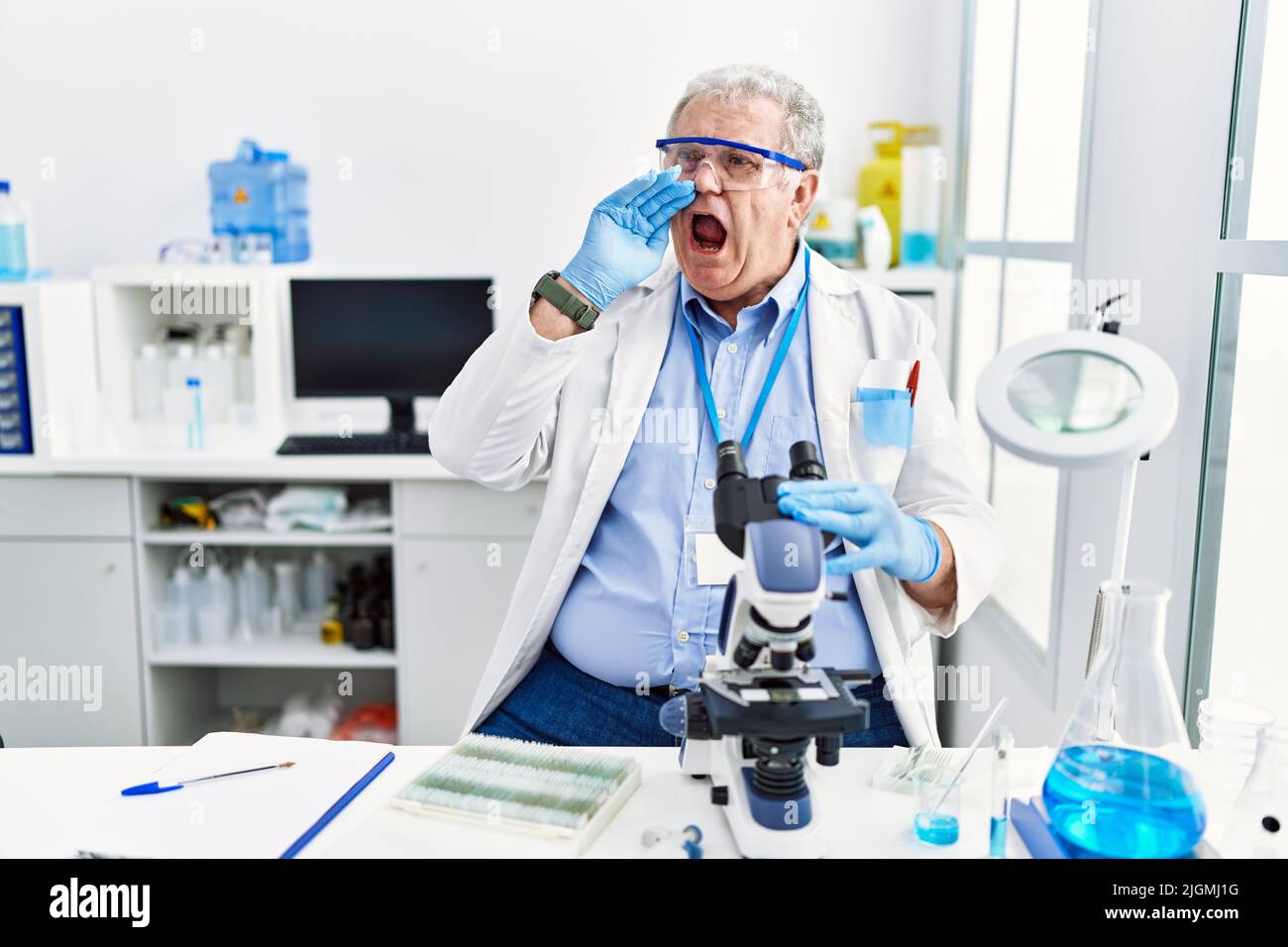 Senior caucasian man working at scientist laboratory shouting and ...