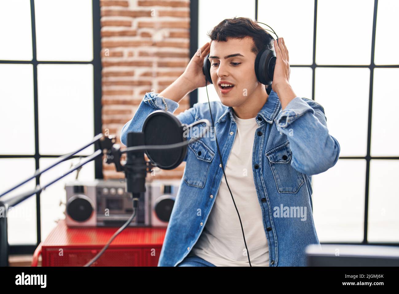 Young non binary man artist singing song at music studio Stock Photo ...
