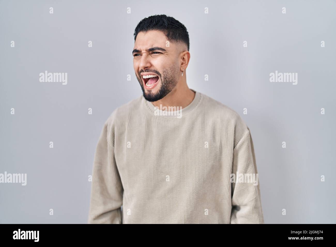Young handsome man standing over isolated background angry and mad ...