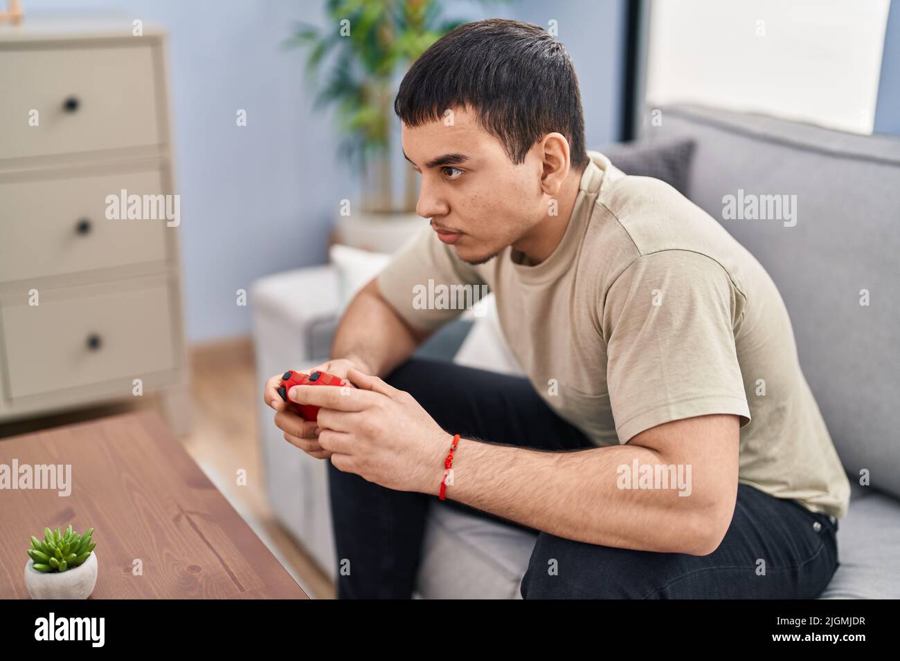 Young man playing video game sitting on sofa at home Stock Photo - Alamy
