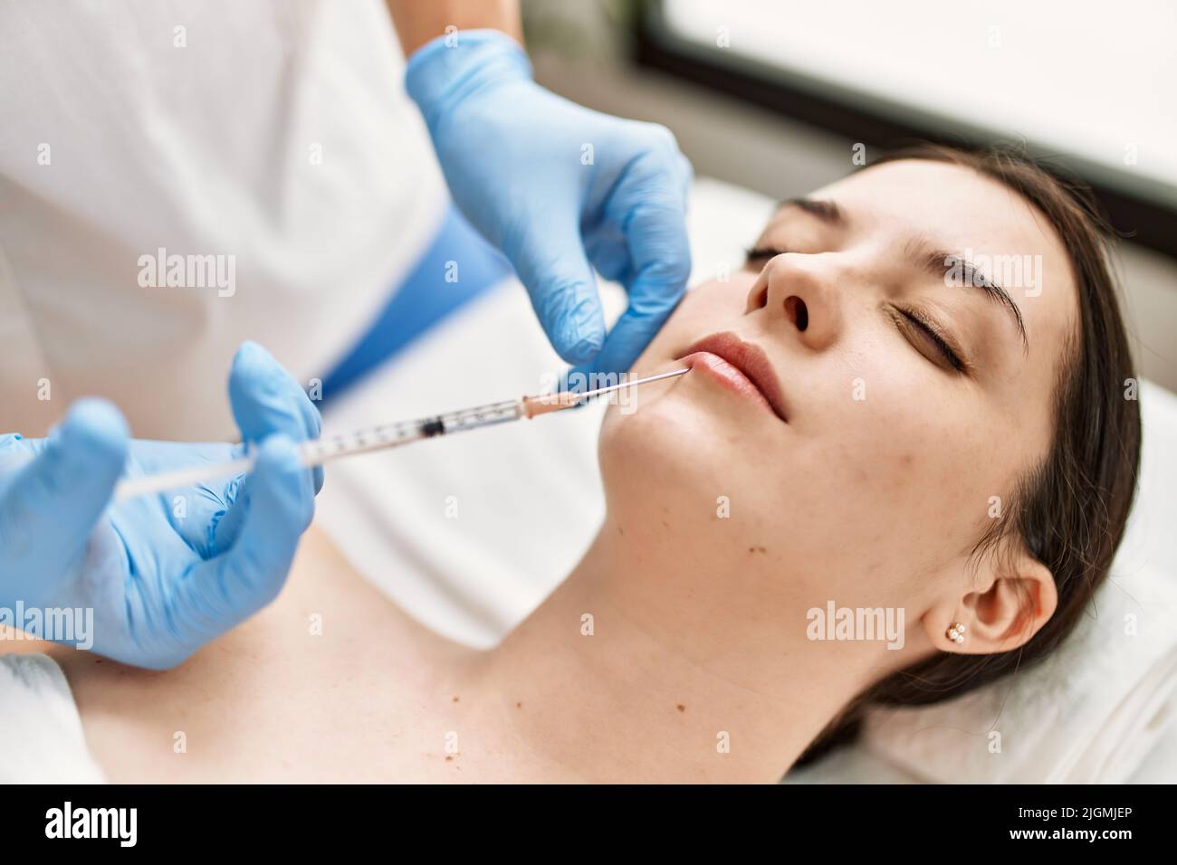 Doctor man injecting botox on woman lips for anti aging treatment at ...