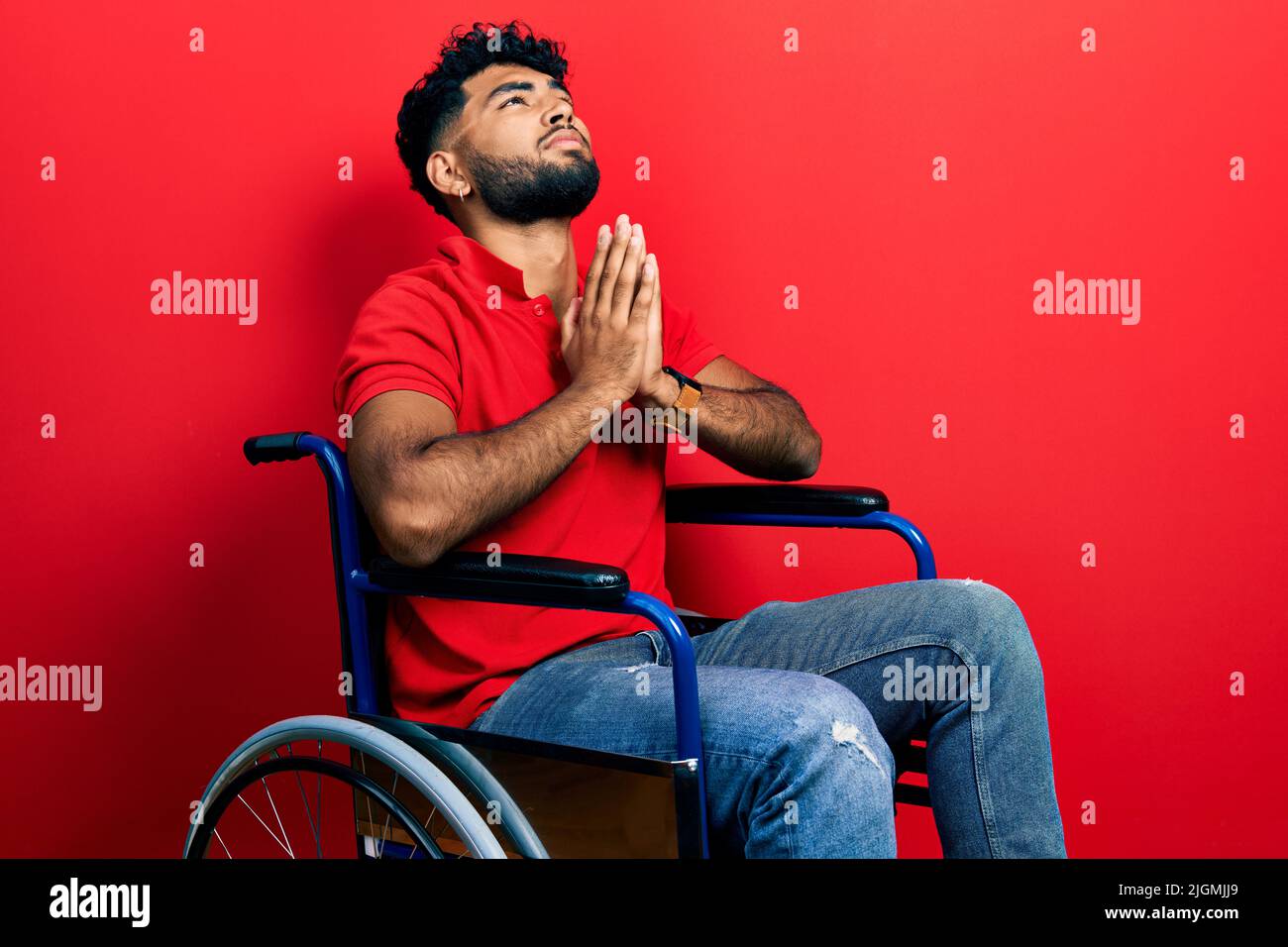 Arab man with beard sitting on wheelchair begging and praying with ...