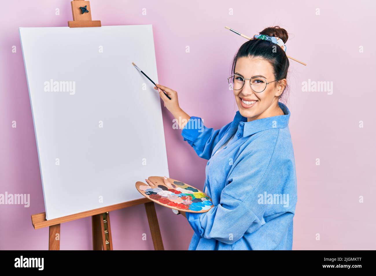 Young beautiful painter woman standing by easel with blank empty canva Stock Photo - Alamy