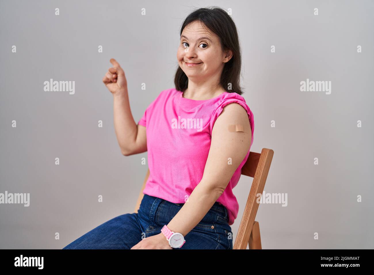 Woman with down syndrome wearing band aid for vaccine injection smiling ...