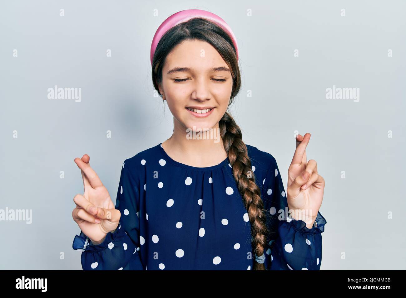 Young brunette girl wearing elegant look gesturing finger crossed ...