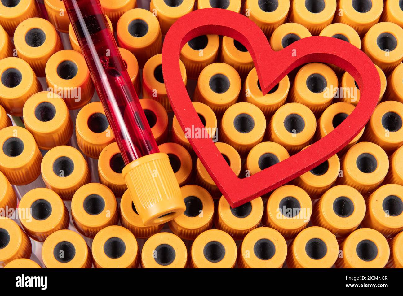 heart shape over blood collection tubes, representing coronary problems ...