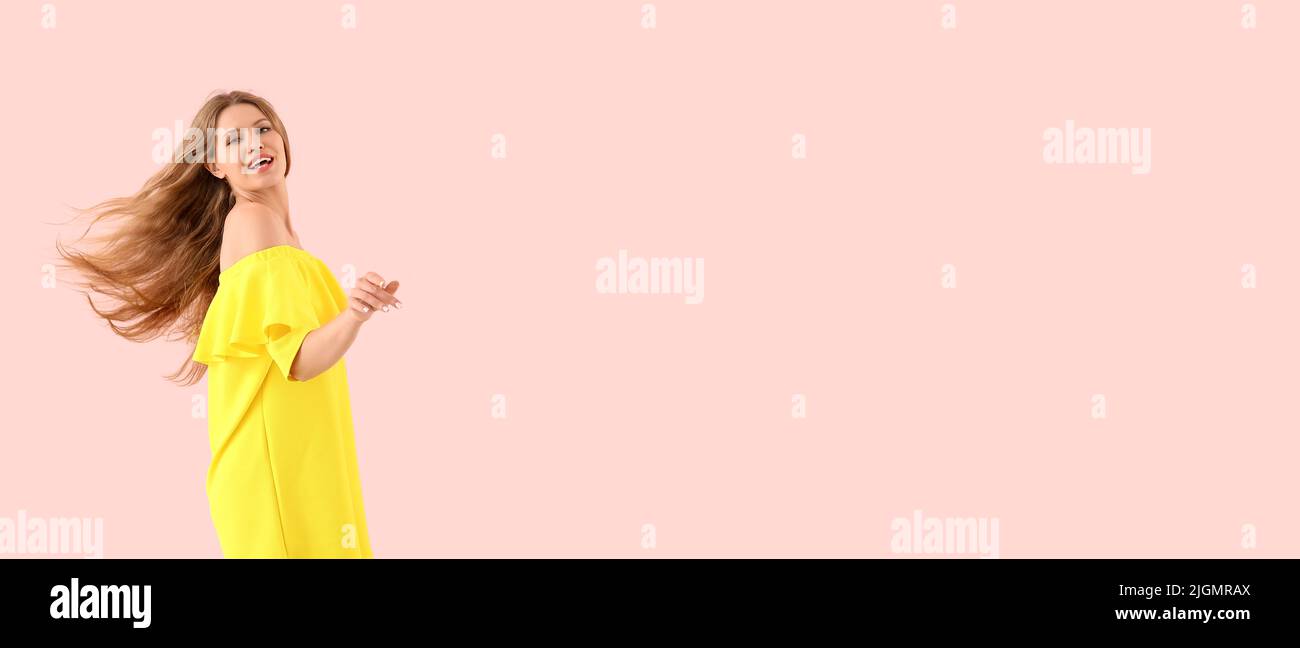 Beautiful young woman dancing against pink background with space for ...