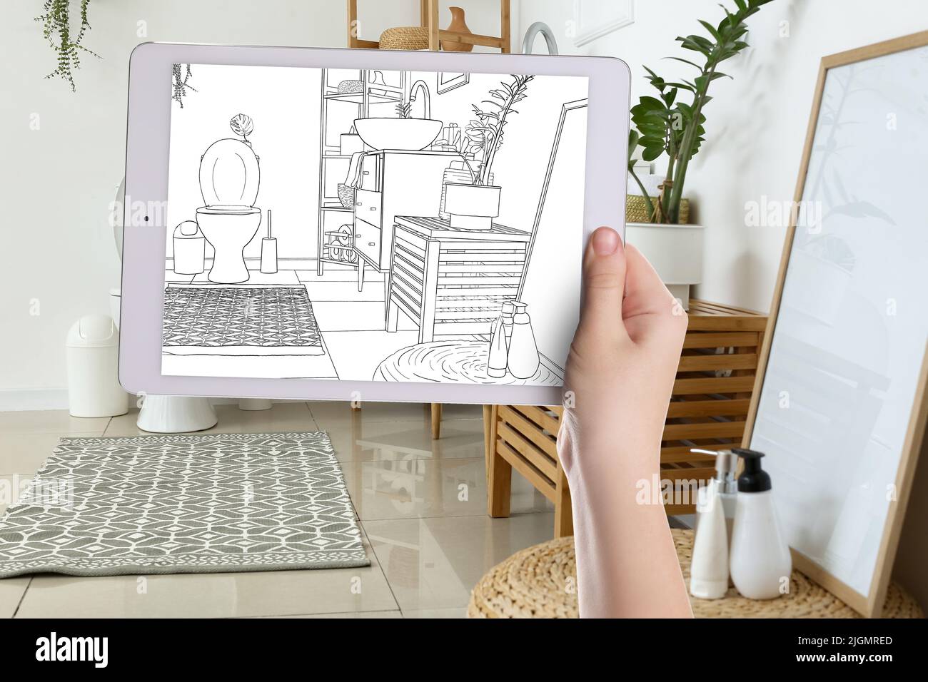 Designer holding tablet computer with drawing of new restroom interior ...