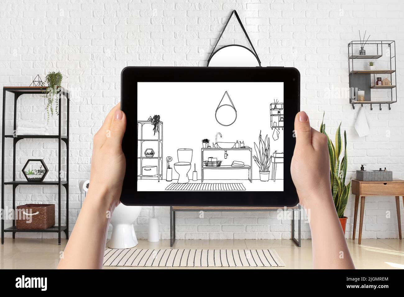 Designer holding tablet computer with drawing of new restroom interior ...