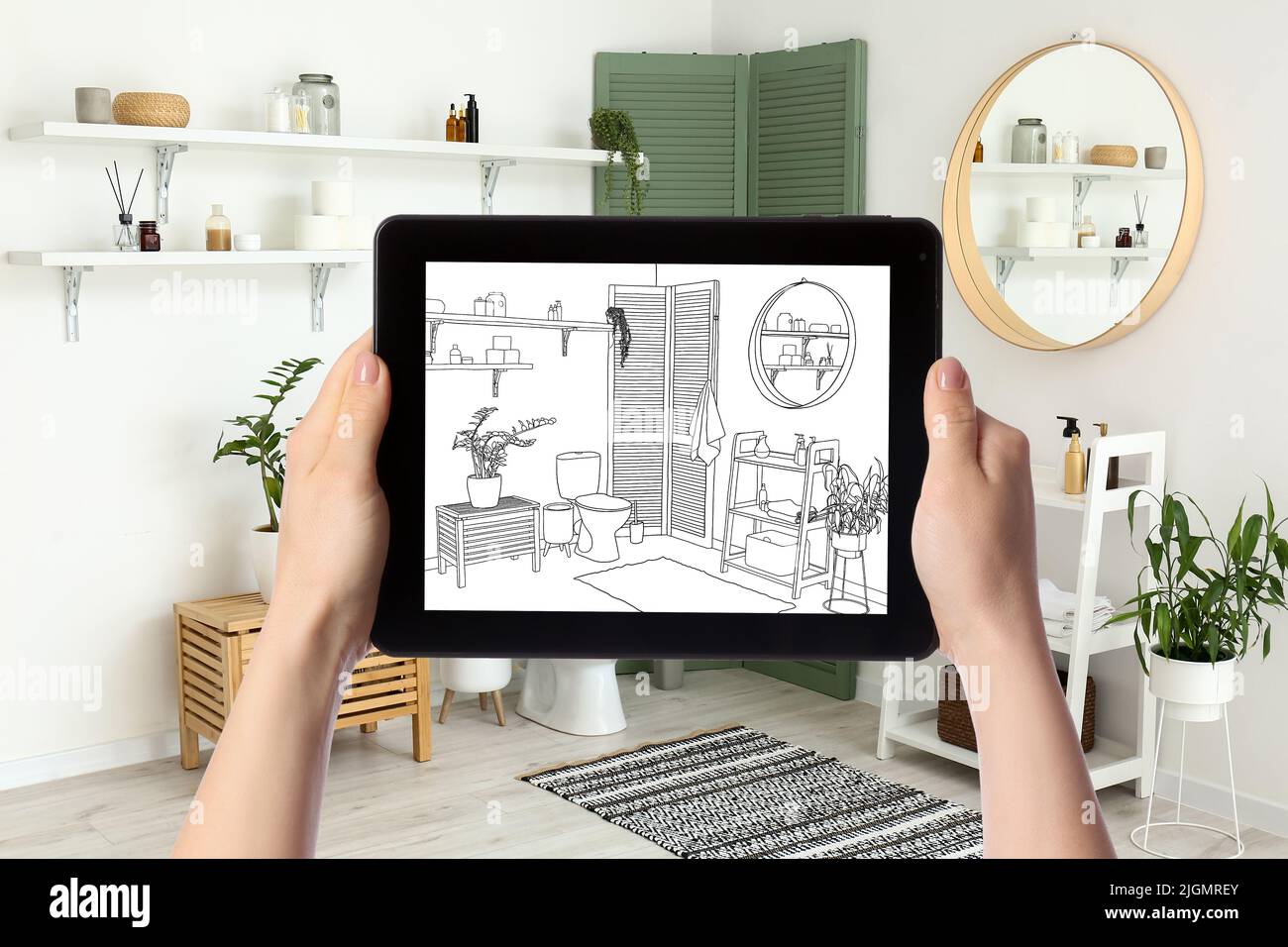 Designer holding tablet computer with drawing of new restroom interior ...