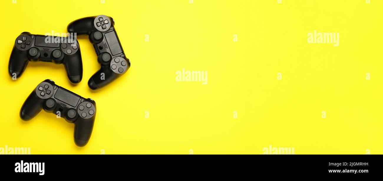 Modern game pads on yellow background with space for text Stock Photo ...
