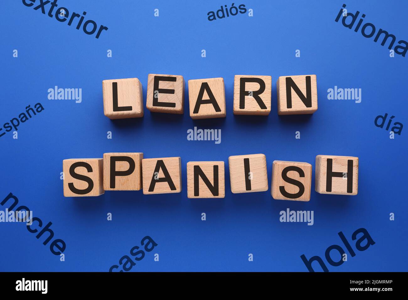 Text LEARN SPANISH made of wooden cubes on blue background, top view ...