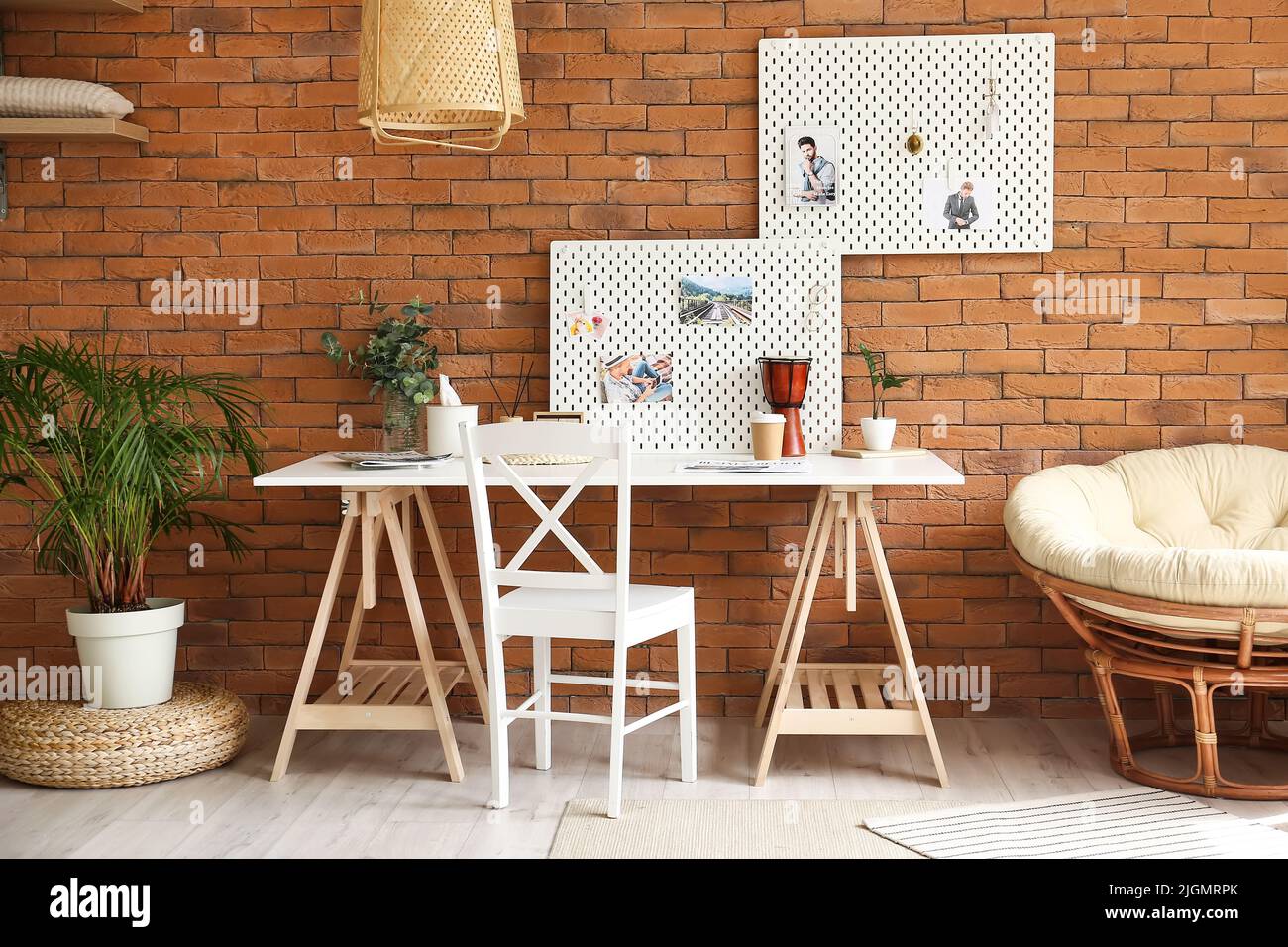Interior of modern office with workplace, peg boards and houseplants ...