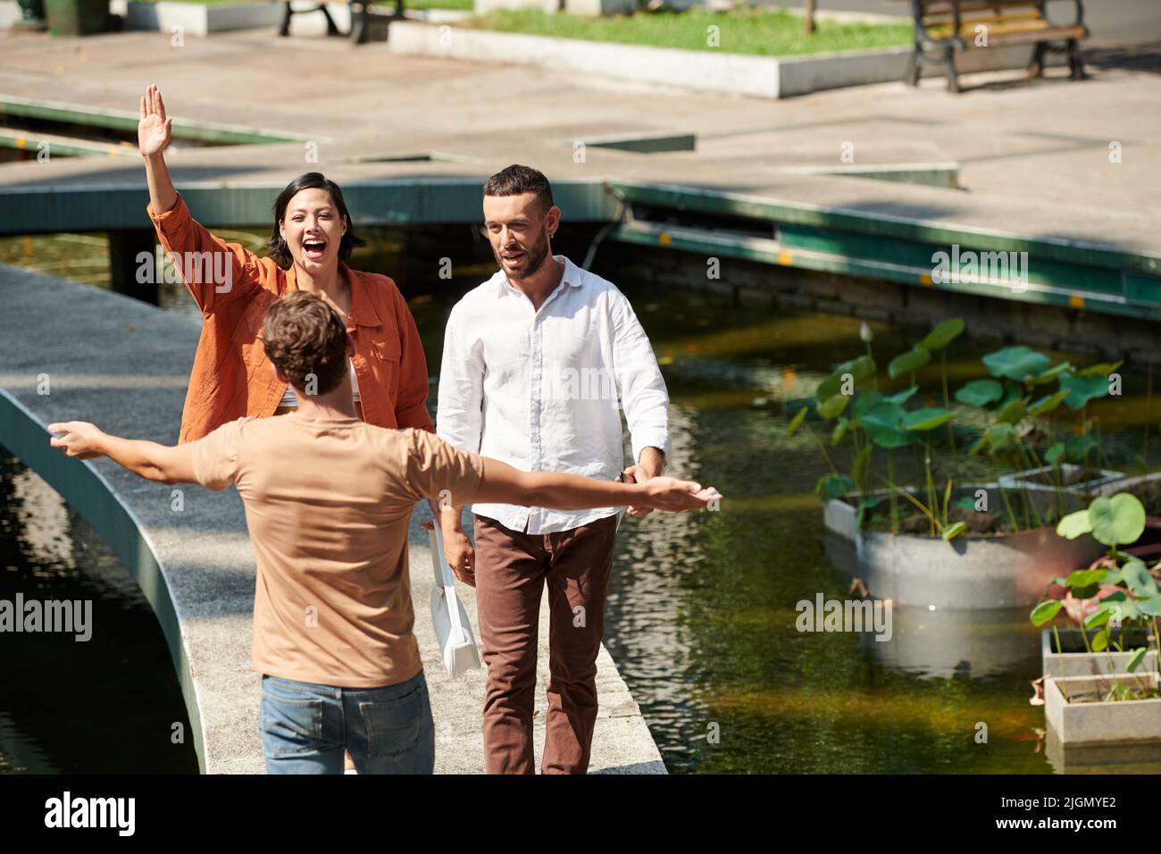 Excited young people happy to see their old friend Stock Photo - Alamy