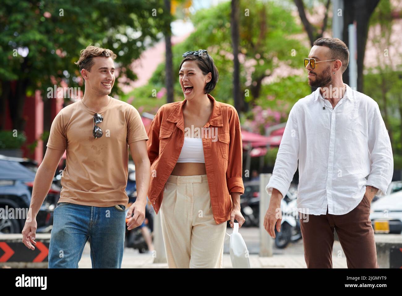 Happy excited adult friends walking around city Stock Photo - Alamy