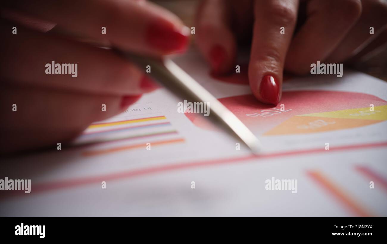 Female hand pointing on colourful diagrams in annual report Stock Photo ...