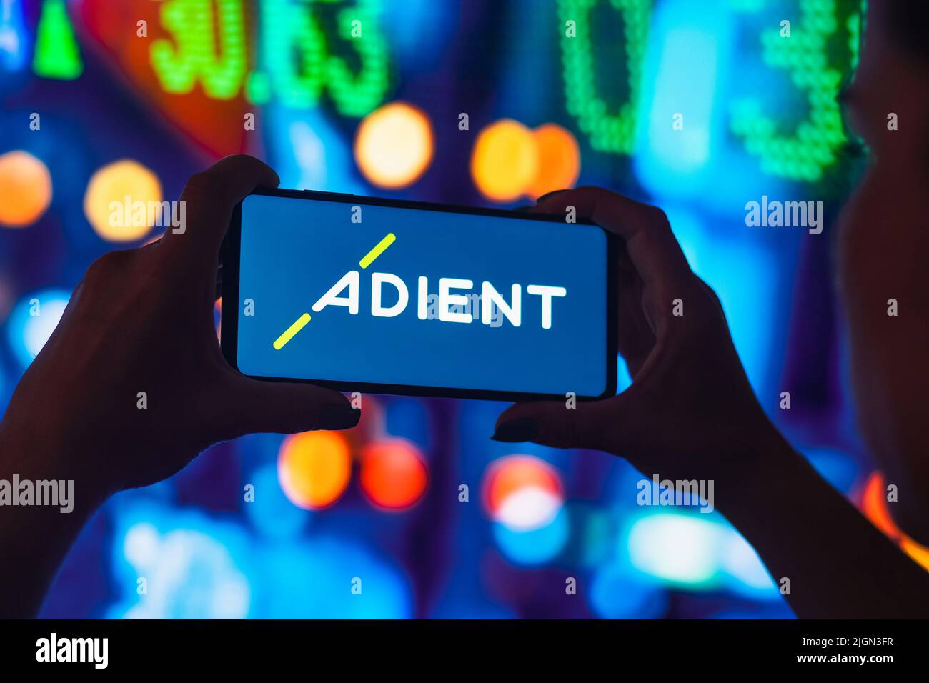 In this photo illustration, a silhouetted woman holds a smartphone with ...