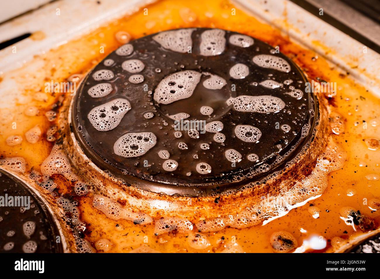 A very heavily soiled old electric kitchen stove in burnt brown soot ...