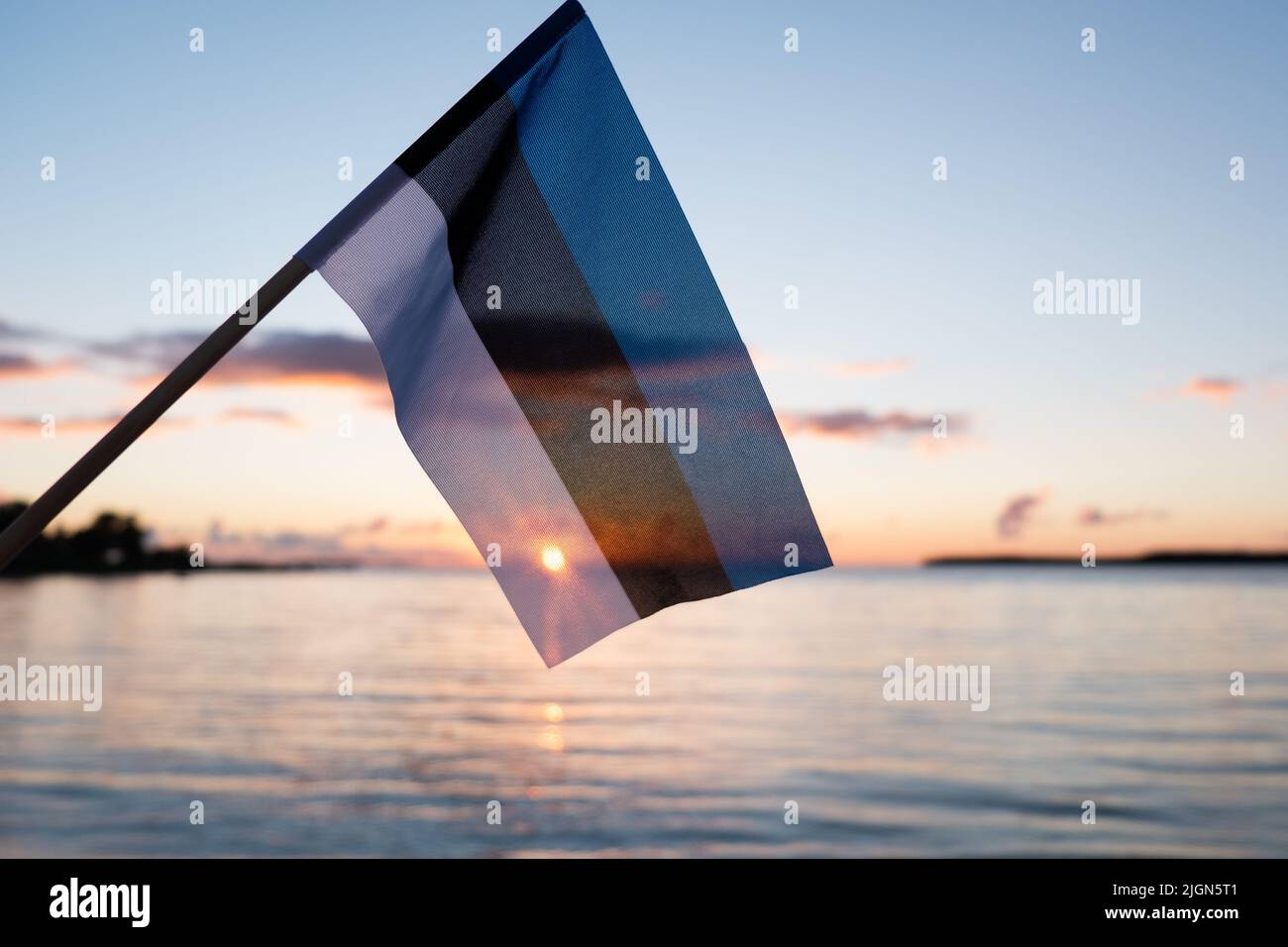 Estonian flag waving at sunset. Flag of Estonia on evening beach ...