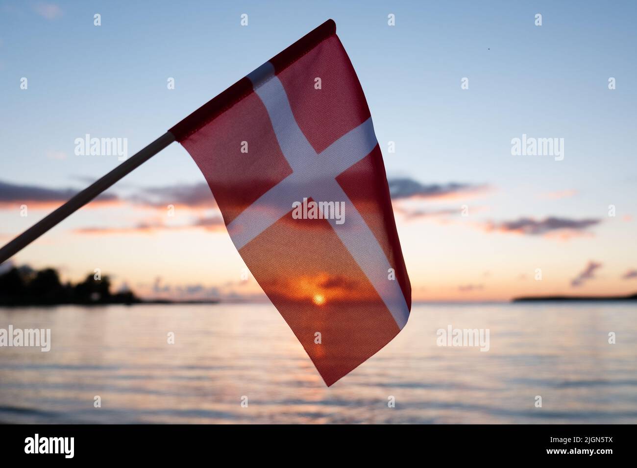 Flag of Denmark on evening beach background. Danish flag waving at ...