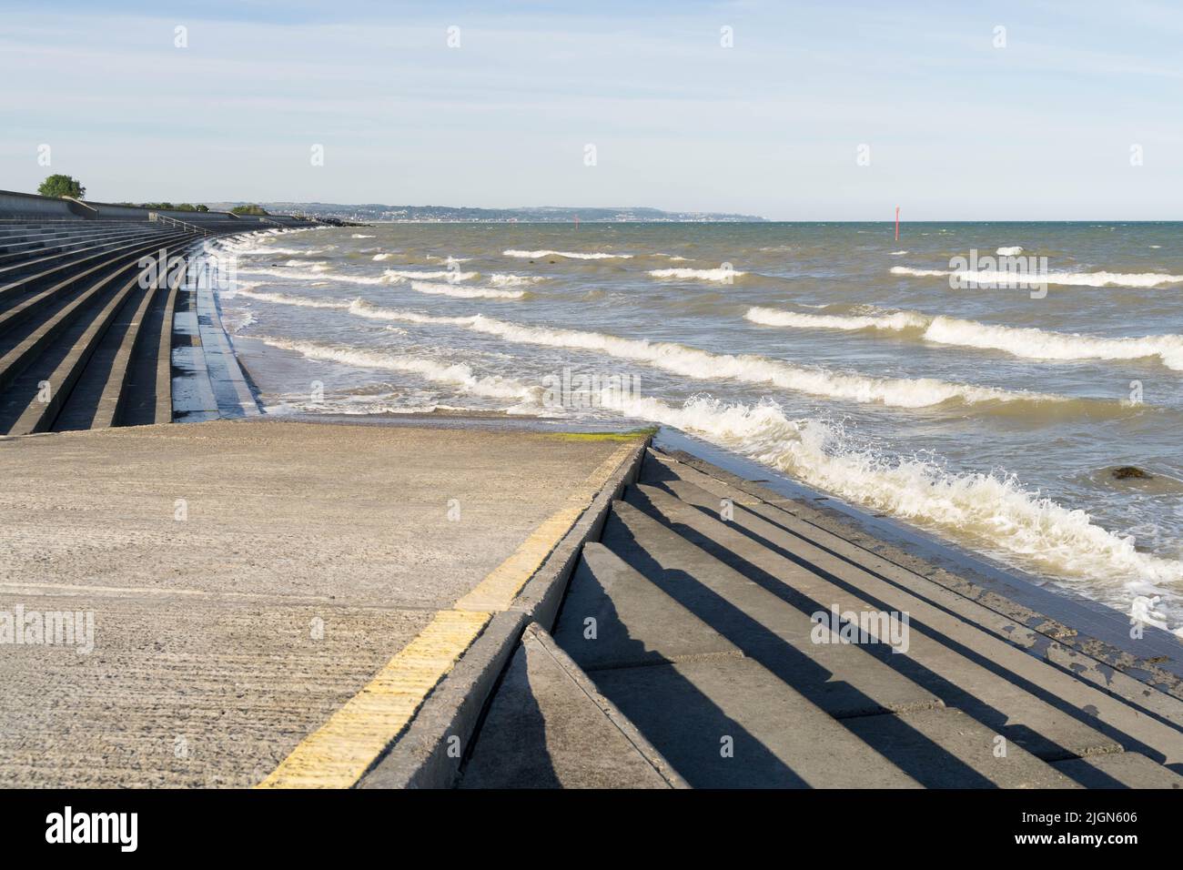 rising tidal wave beating on the concrete sea front promenade Kent ...