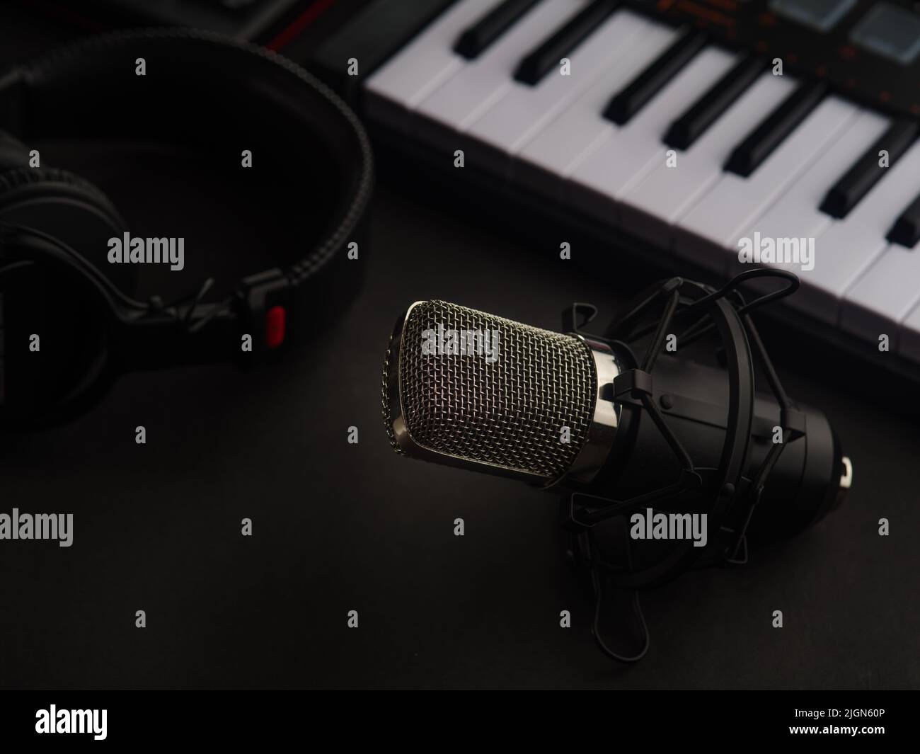 Studio headphones, studio microphone and midi keyboard on a gray ...