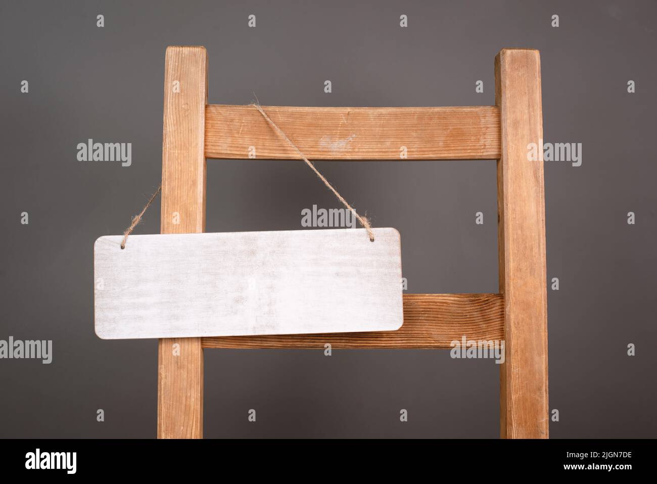 Blank wooden sign is hanging on a chair, welcome and sale concept, copy ...