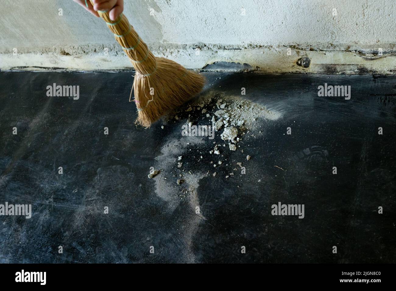 A worker sweeps construction debris with a broom, gunpowder and small ...