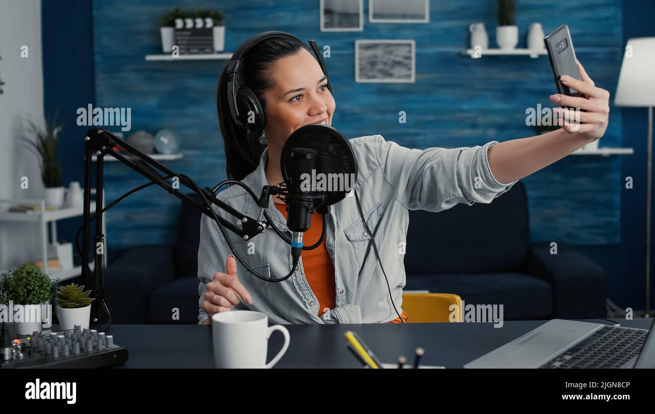 Creative content creator taking selfie photo while recording podcast ...