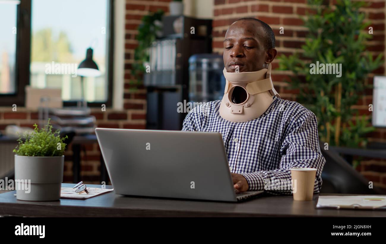 Injured office consultant wearing cervical collar at startup job, using ...