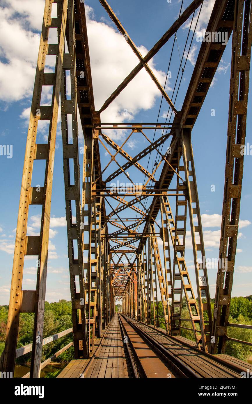 The metal structure of the railway viaduct over the river against the ...