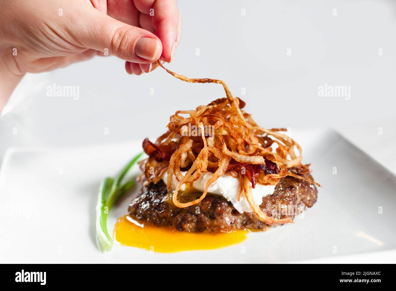 Eating of meat cutlet with onions and egg Stock Photo - Alamy
