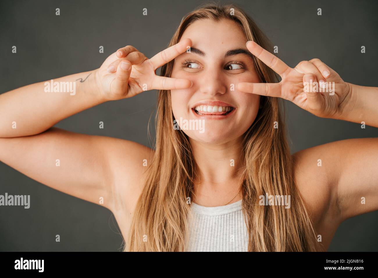Close up Fun loving female making peace sign the studio Stock Photo - Alamy