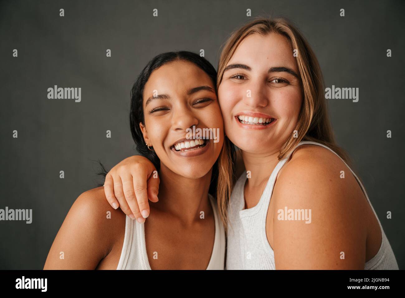 Happy smiling girlfriends in a studio posing Stock Photo - Alamy
