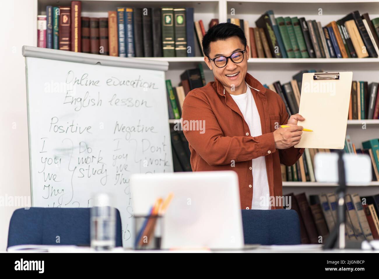 Korean Teacher Having Online Class Showing Flipboard To Laptop Indoors ...