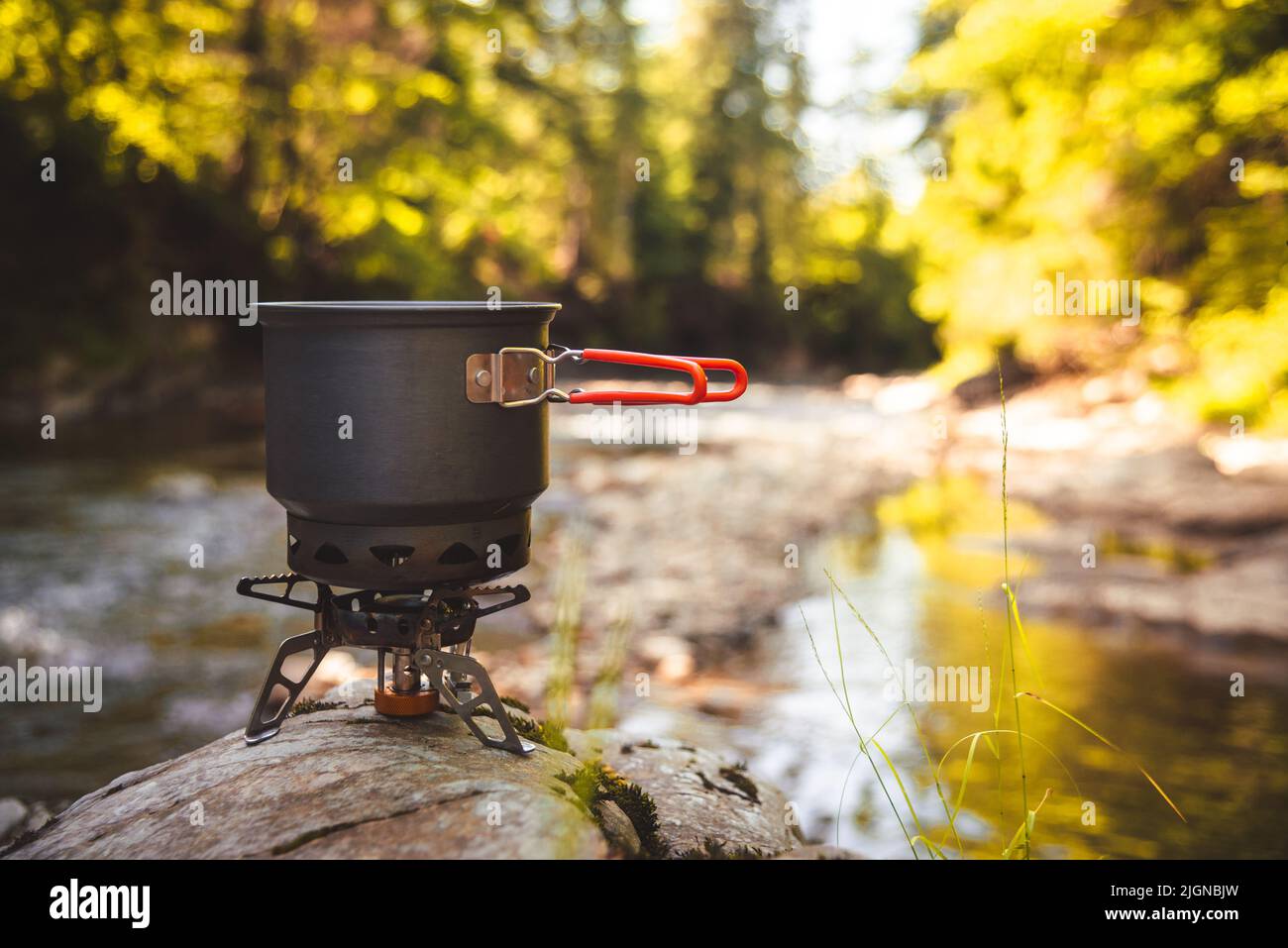 Cooking food using camping gas during the hike Stock Photo - Alamy