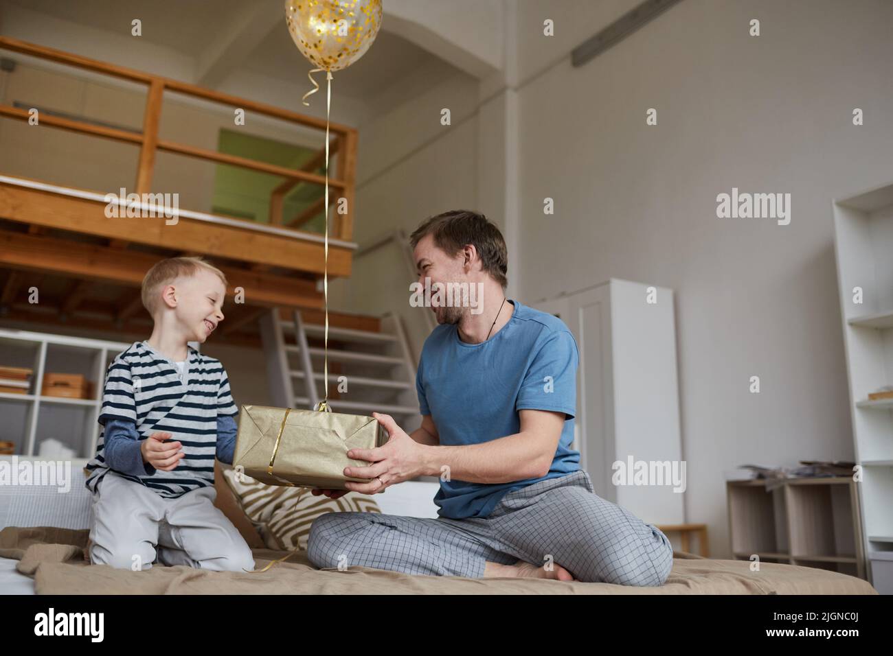 Happy handsome young father in pajamas celebrating son birthday and ...