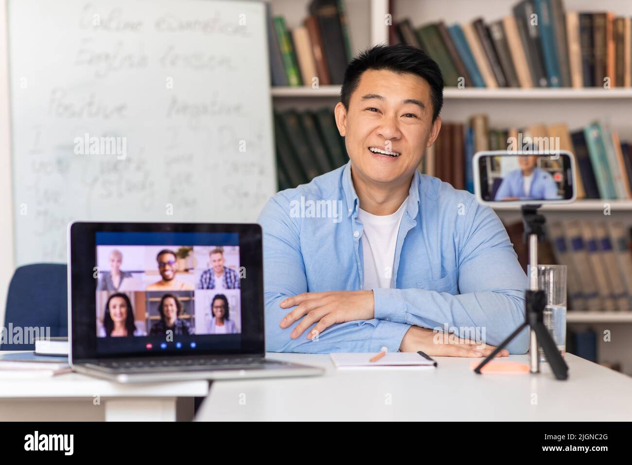 Asian Male Teacher Video Calling Talking With Students At Workplace ...
