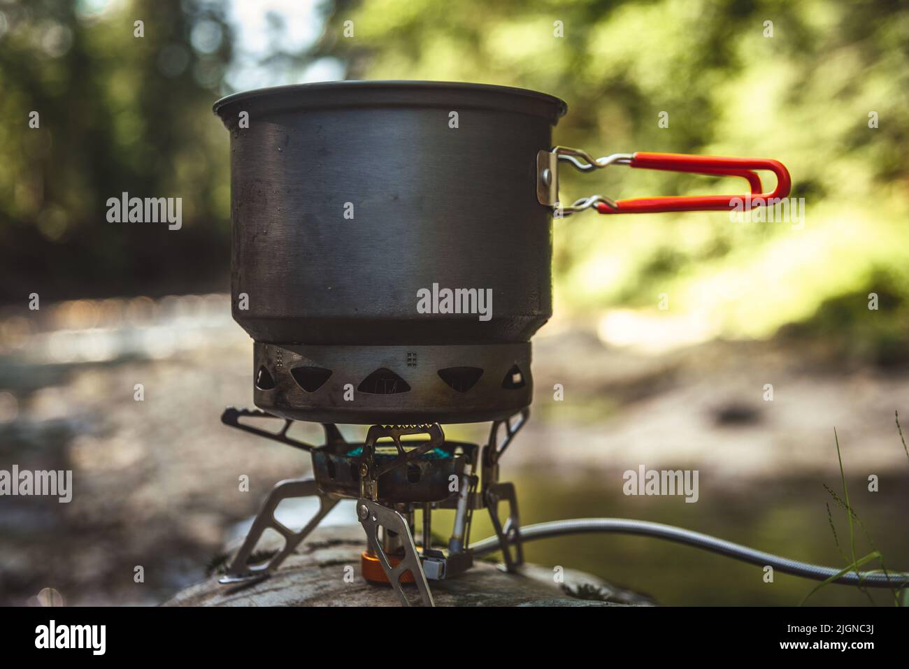 Cooking food using camping gas during the hike Stock Photo - Alamy