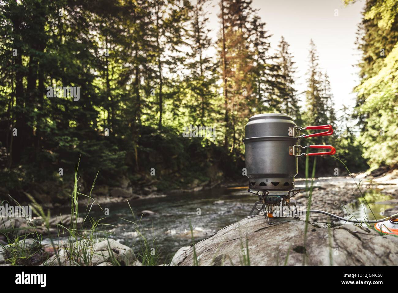 Cooking food using camping gas during the hike Stock Photo - Alamy