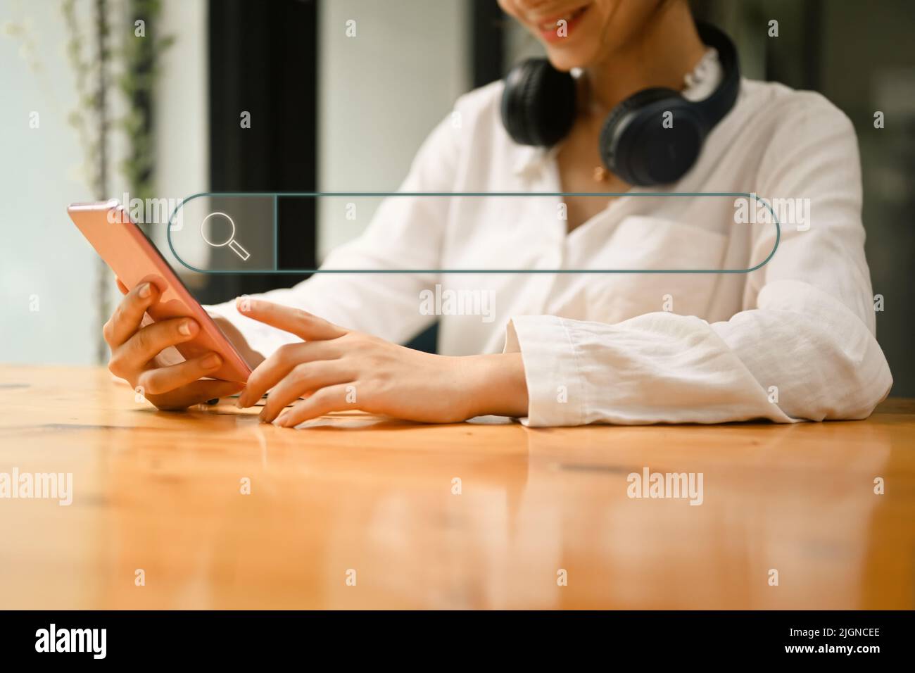 Smiling asian woman using smart phone with virtual screen of search bar ...